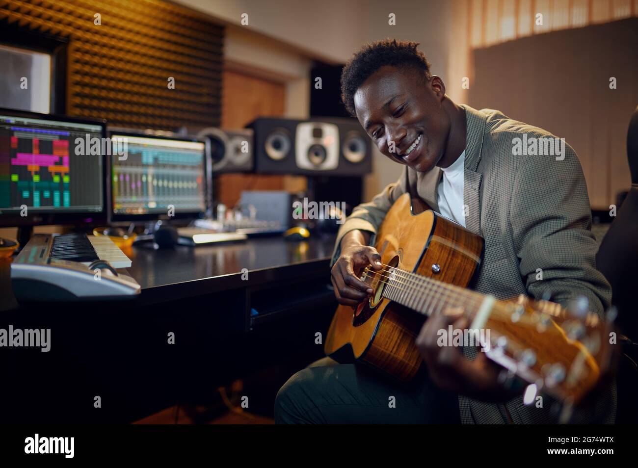 Male performer with guitar, recording studio Stock Photo - Alamy