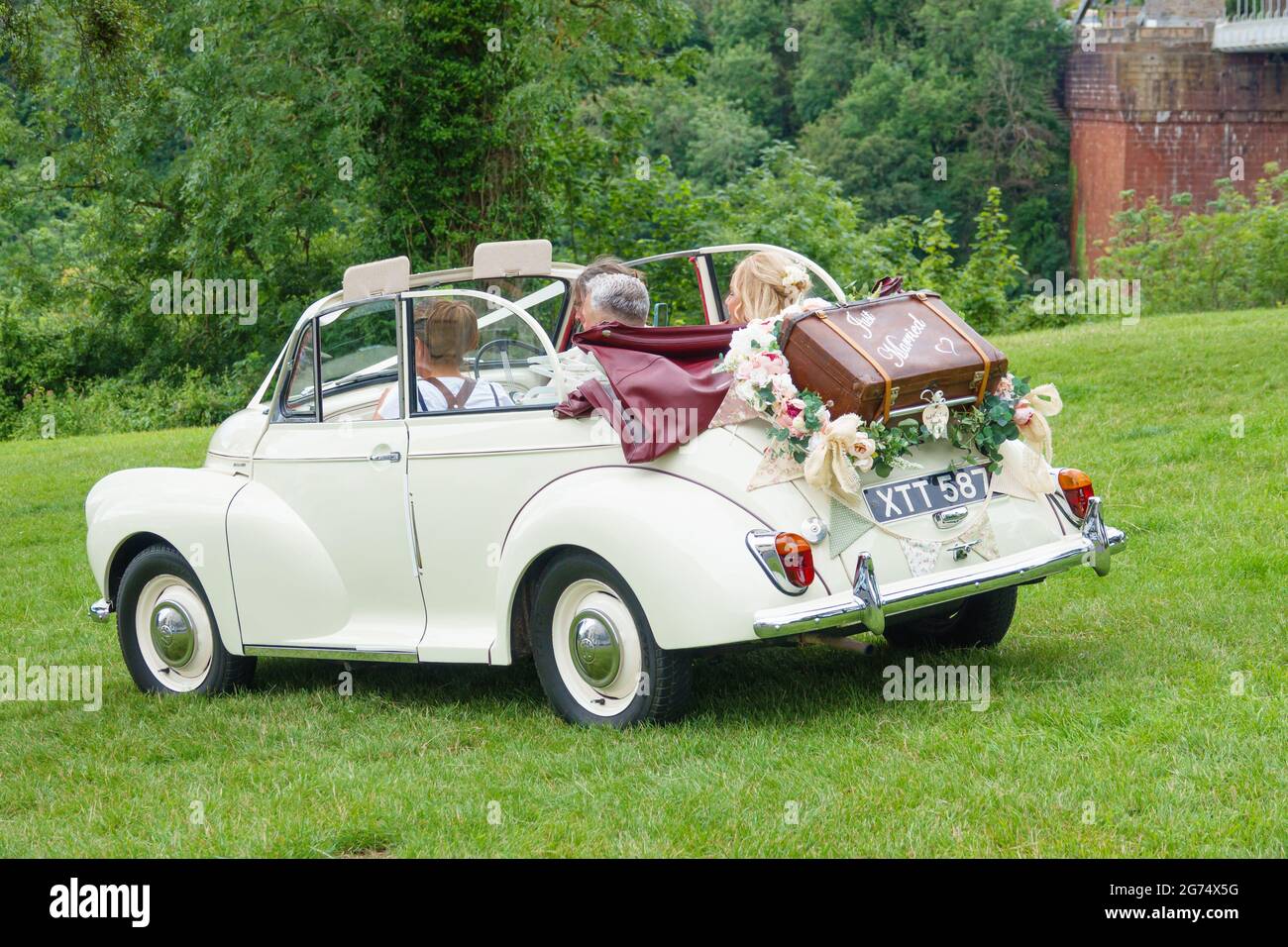just married couple in a white Morris Minor convertble wedding car ...