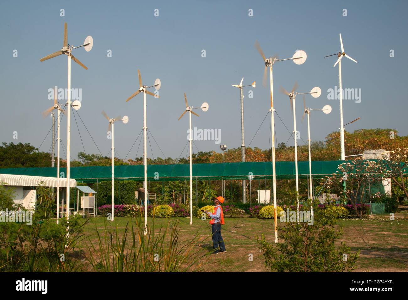 Asian man, engineer wearing a helmet Control the wind turbine and ...