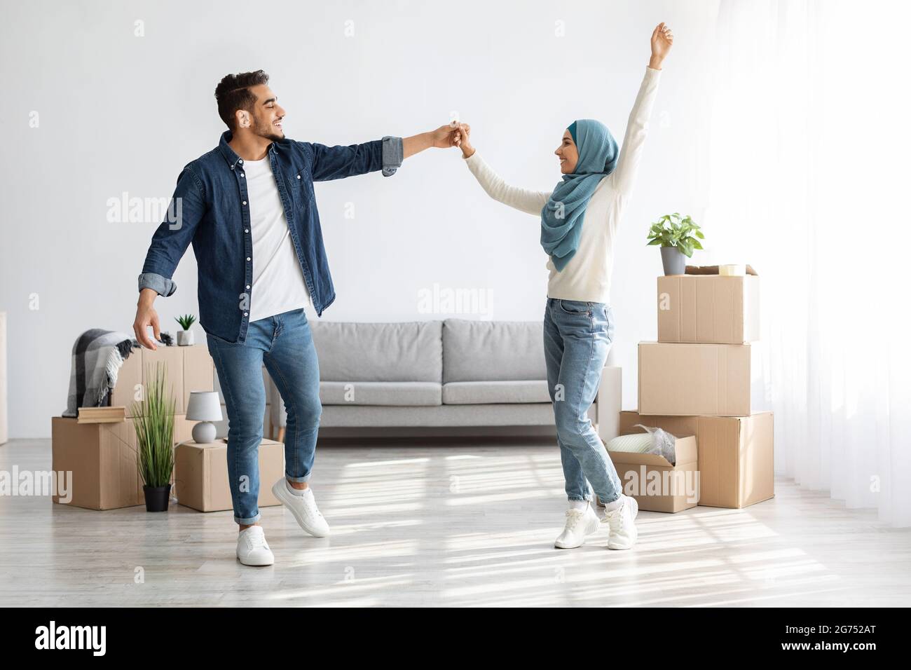 Joyful arab man and woman dancing in their new house Stock Photo - Alamy