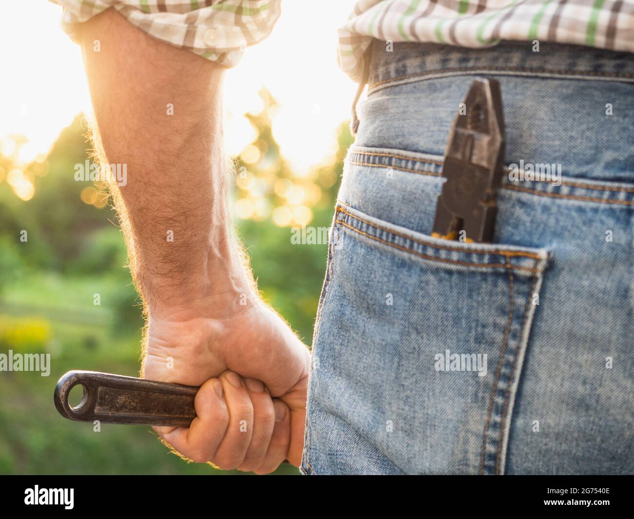 Handsome man in work clothes, holding tools in his hands against the ...