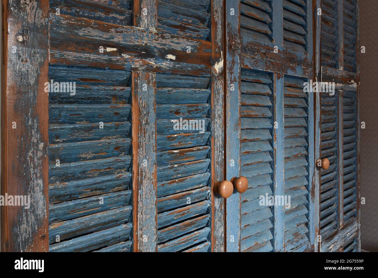 The old and worn-out wooden door of a closet captured inside an ...