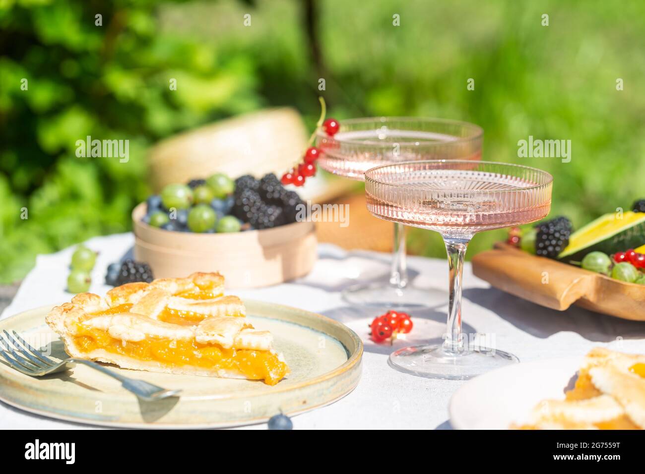Outdoor summer lifestyle with a gourmet picnic laid out in a garden ...