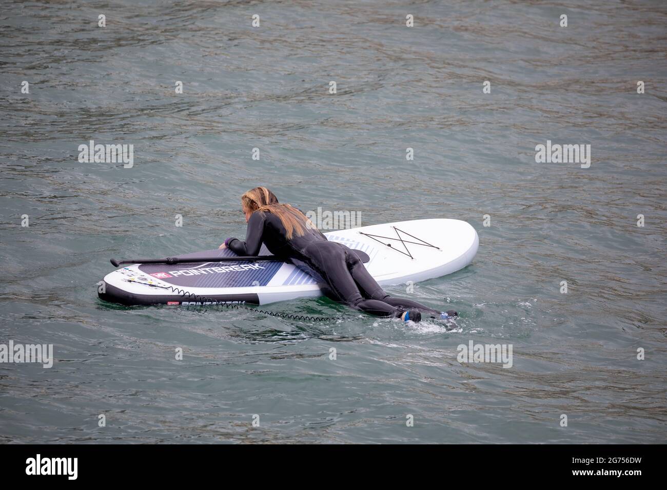 Girls paddle boarding on the sea in Porthleven Harbour, Cornwall Stock ...