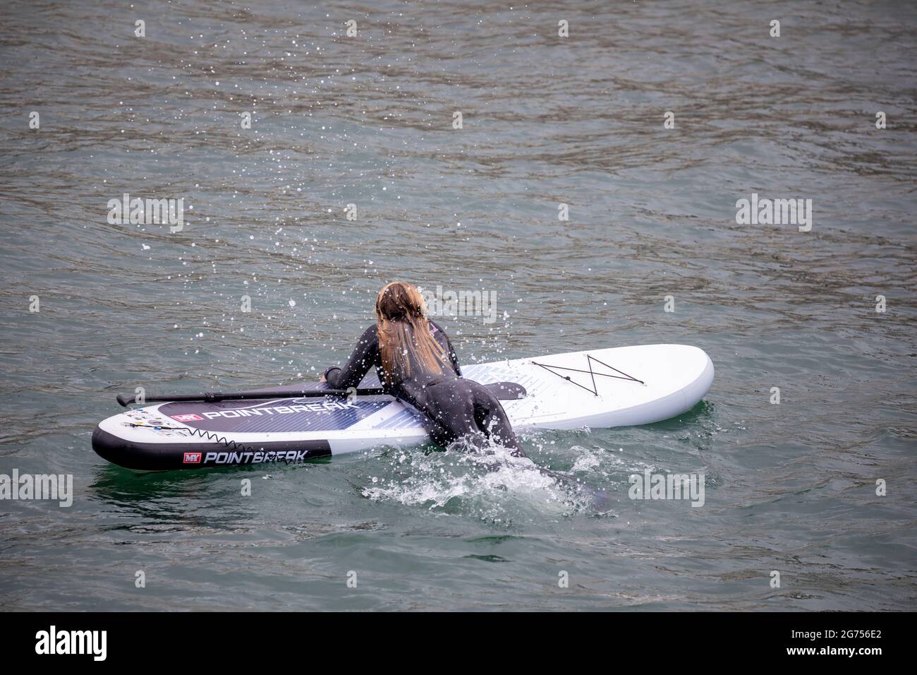 Girls paddle boarding on the sea in Porthleven Harbour, Cornwall Stock ...