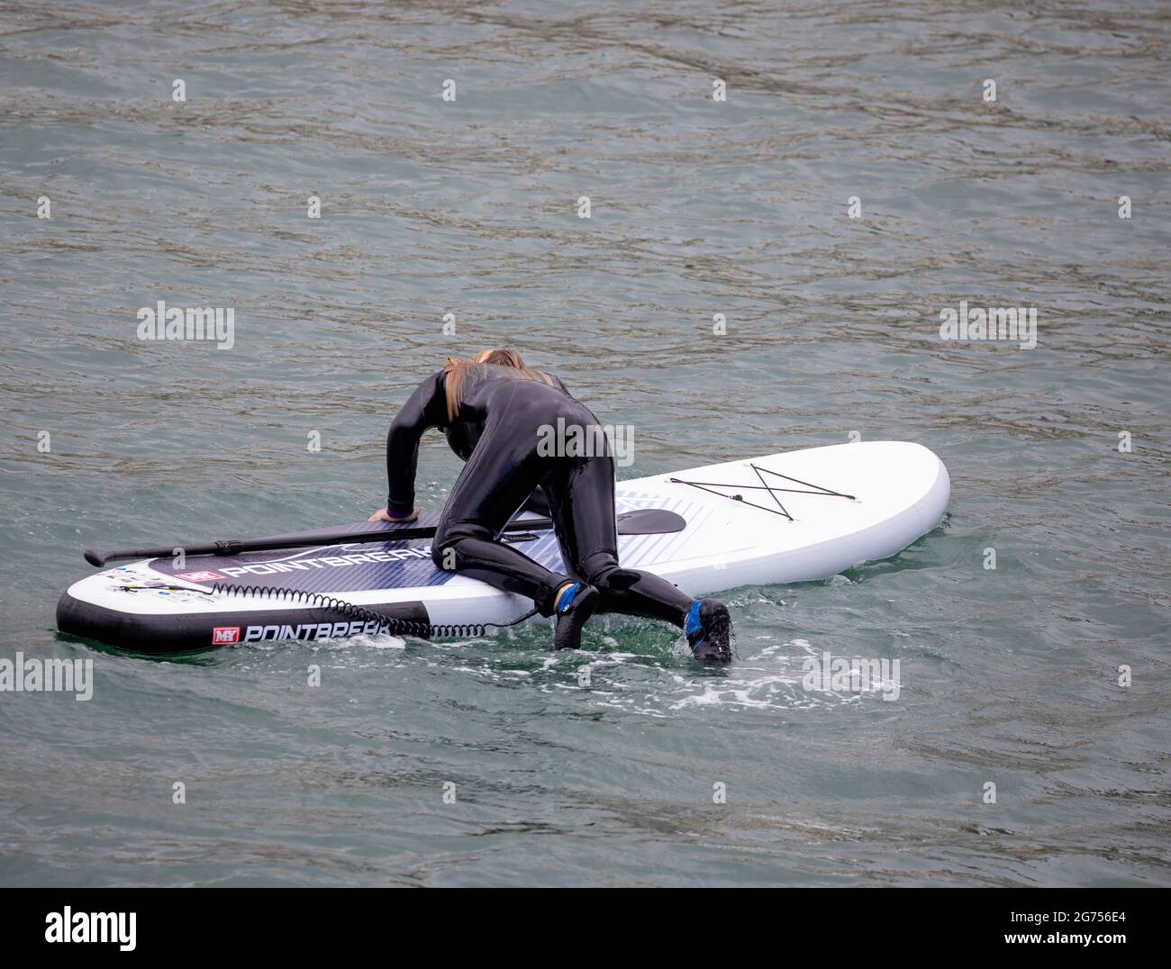 Girls paddle boarding on the sea in Porthleven Harbour, Cornwall Stock ...