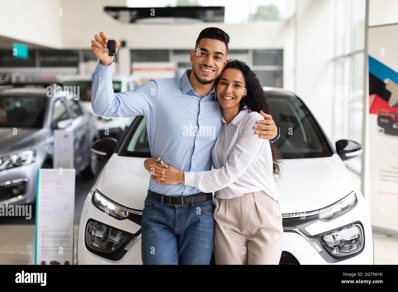 Happy young family buying new car in luxury showroom Stock Photo - Alamy