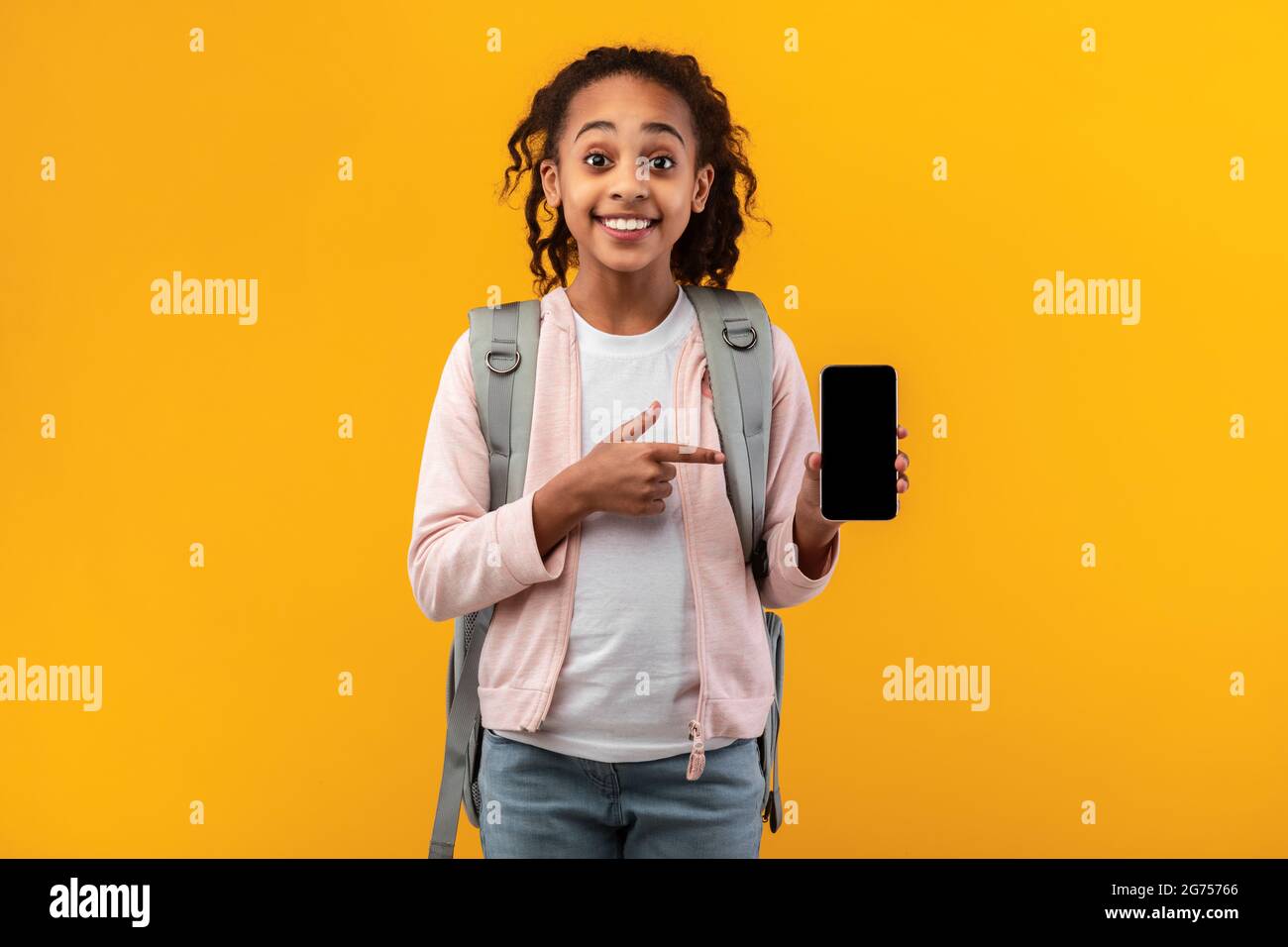 Excited black girl showing blank empty smartphone screen and pointing ...