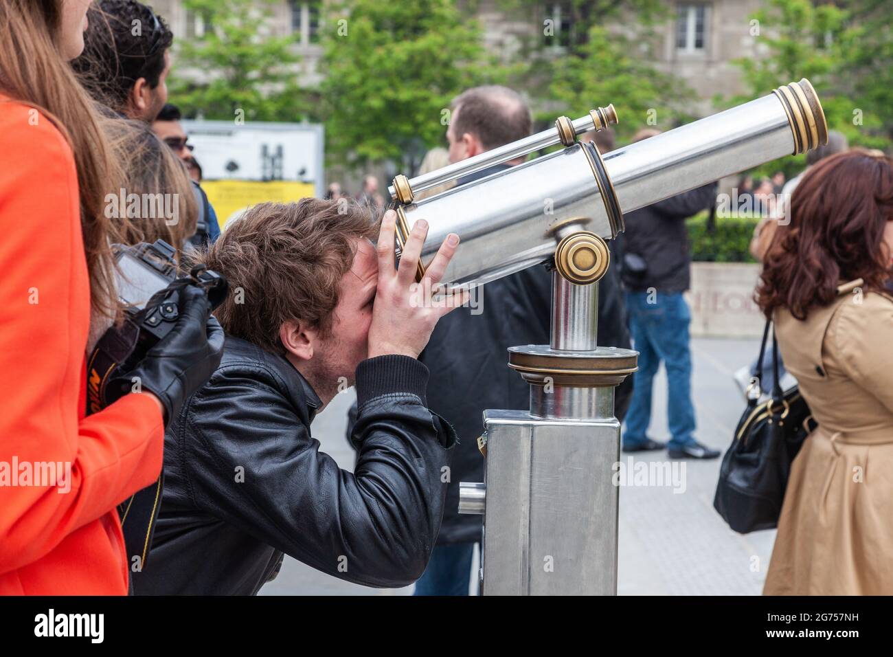 Person looking in the distance through a public telescope. Paris Stock ...