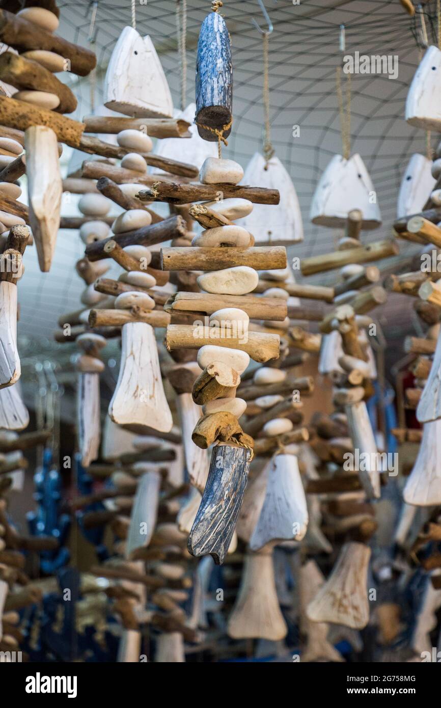 A vertical shot of a beautiful wooden fish for decoration on a string ...
