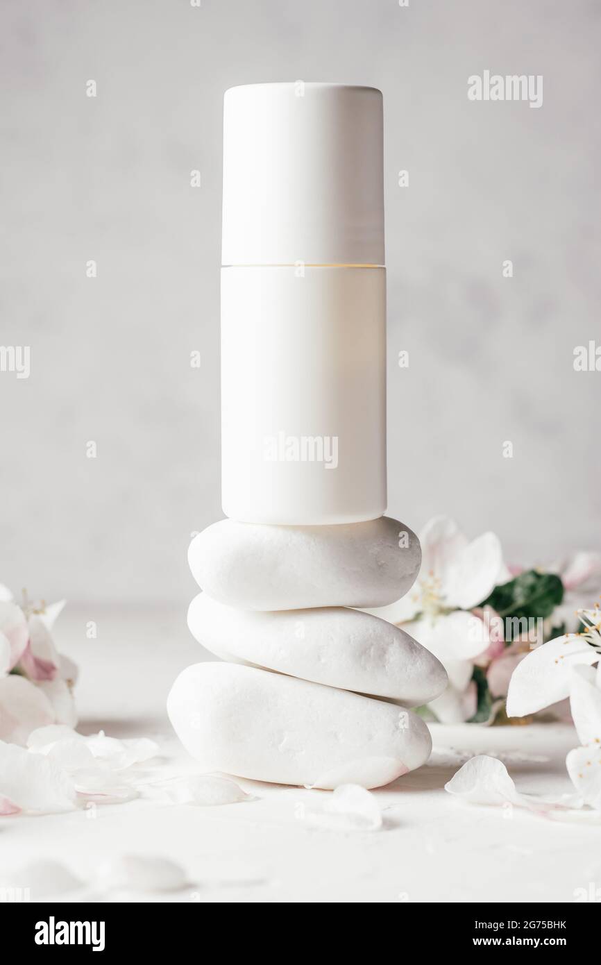 Antiperspirant roll-on deodorant on stack of white pebble stones on ...