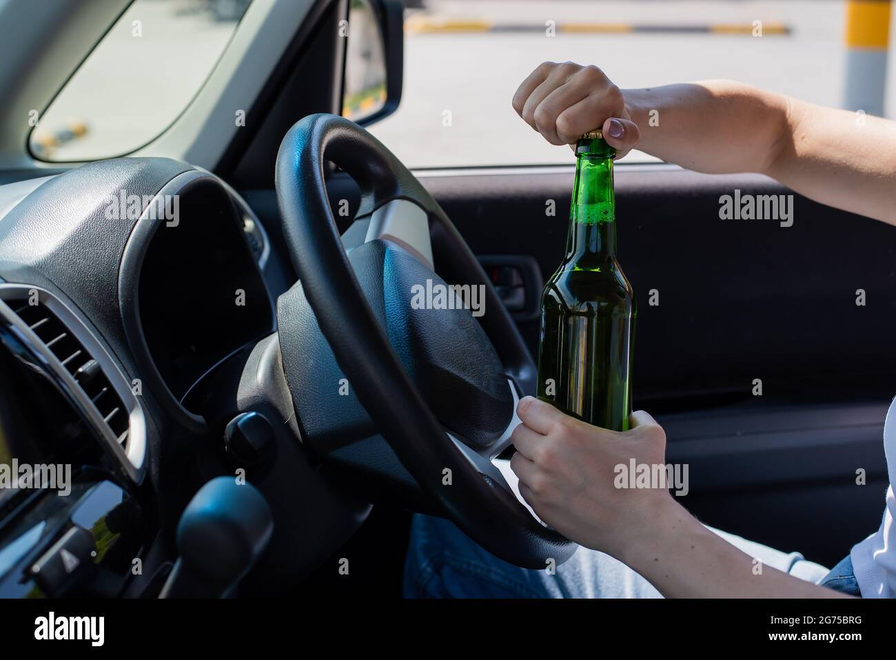 A faceless woman opens a bottle of beer while driving a car. Breaking ...