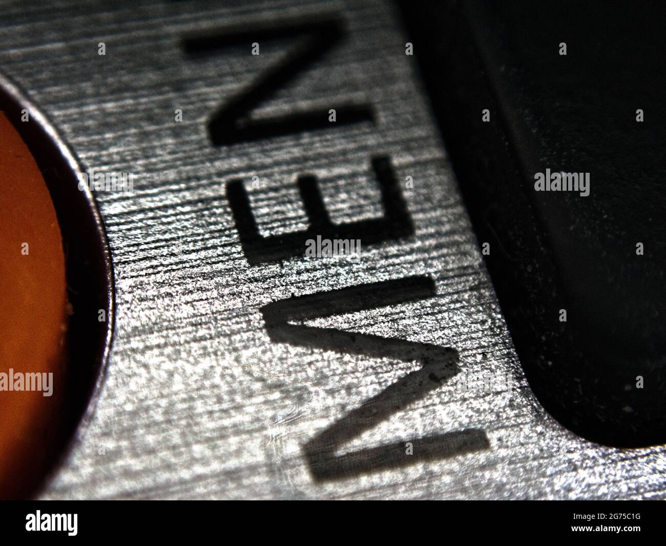 A closeup shot of the word "men" written on a shiny silver surface ...