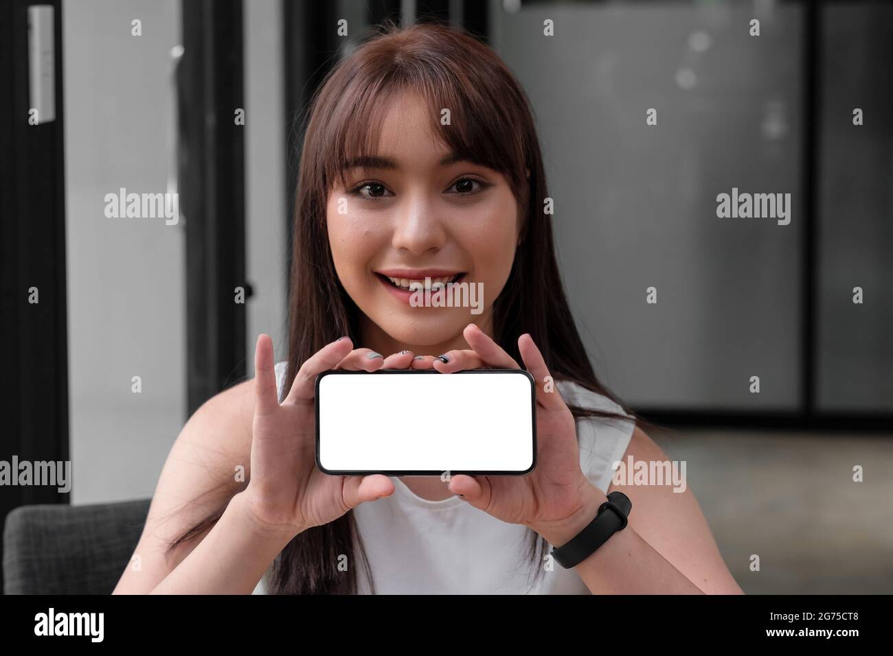 Young asian smiling woman hand holding and showing mobile smart phone ...