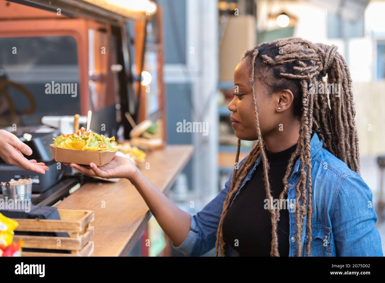 Afro american woman getting a fast food tray from a fast food truck ...