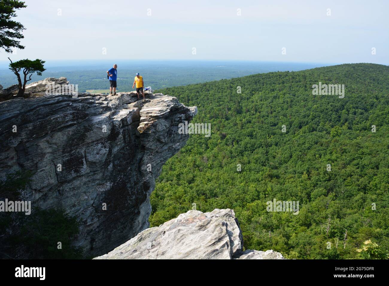Hikers stand near the edge of the overlook at Hanging Rock State Park ...