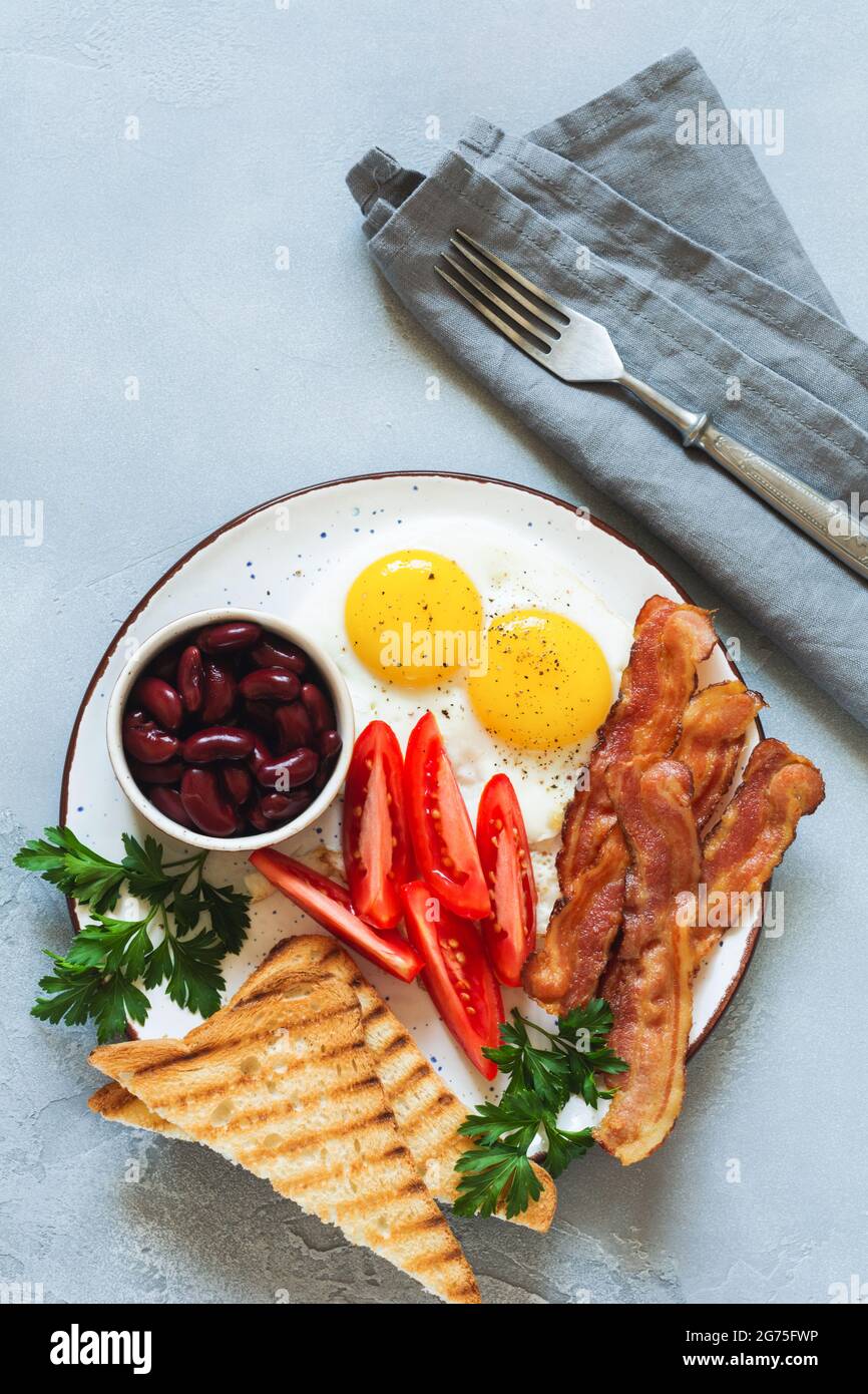 Traditional full English breakfast with fried eggs, sausages, beans ...