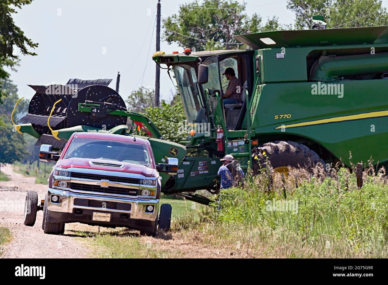 Combine operators attach a 735FD John Deere cutter header to an S770 ...