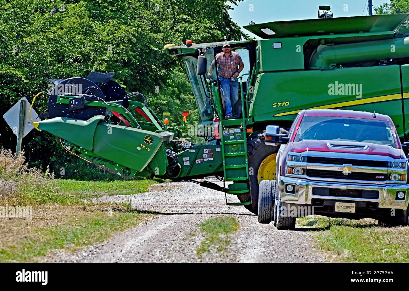 Combine operators attach a 735FD John Deere cutter header to an S770 ...