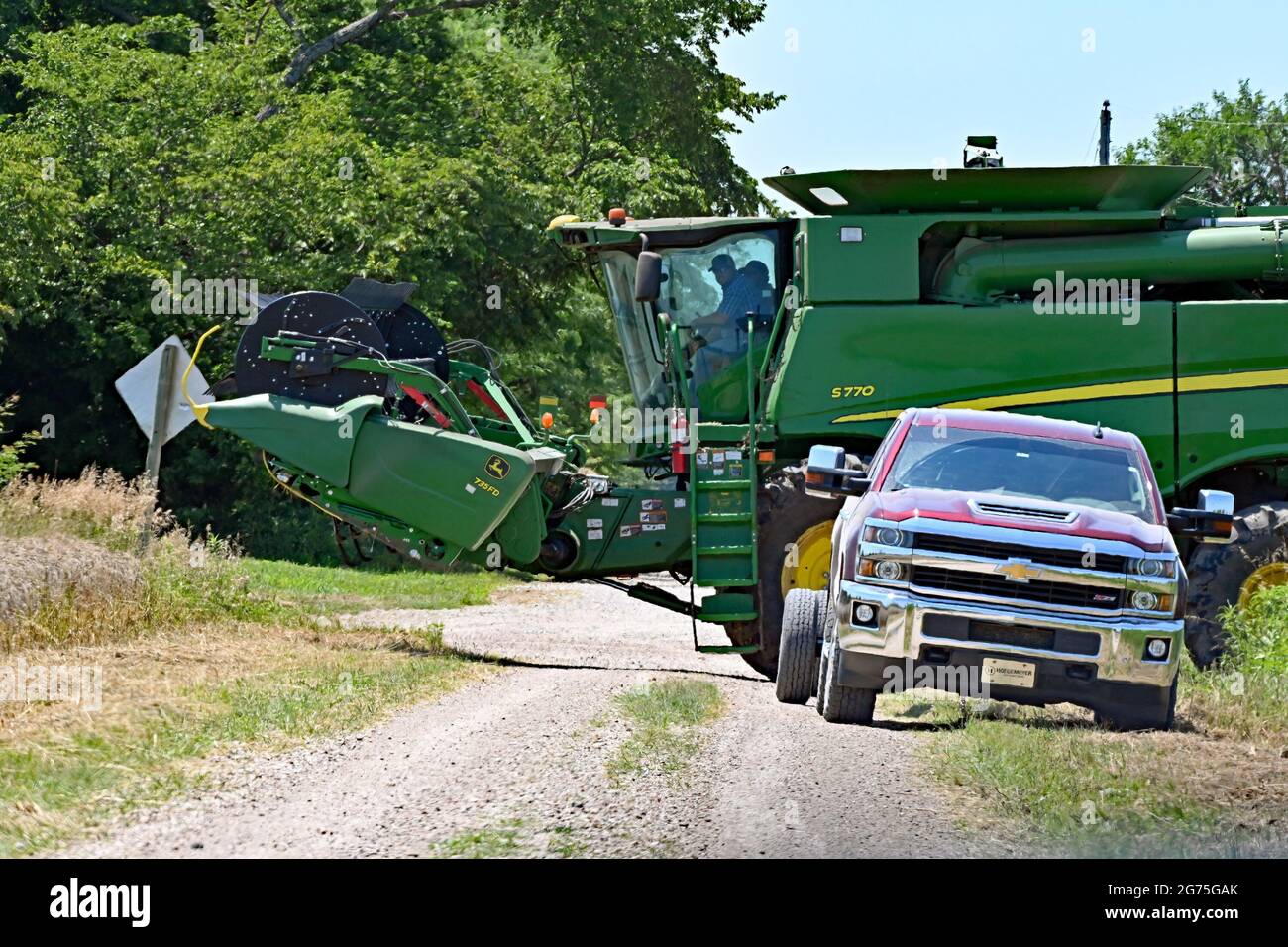 Combine operators attach a 735FD John Deere cutter header to an S770 ...