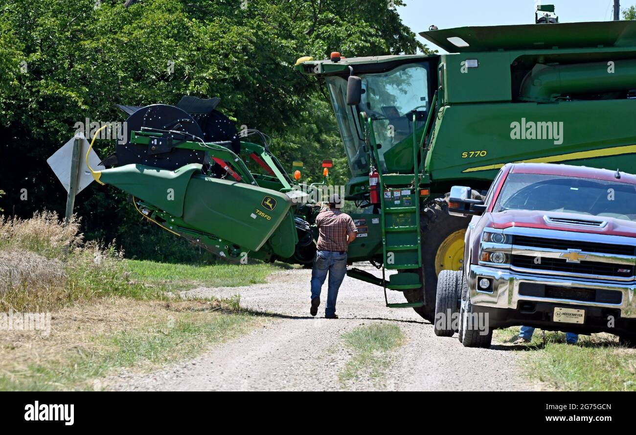 Combine operators attach a 735FD John Deere cutter header to an S770 ...