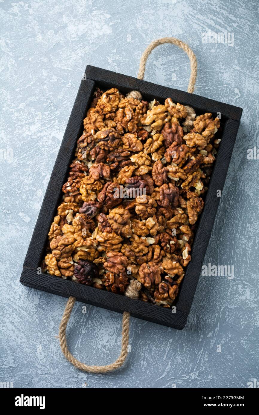 Mature dried walnuts in a wooden box, tasty healthy walnuts. Top view ...
