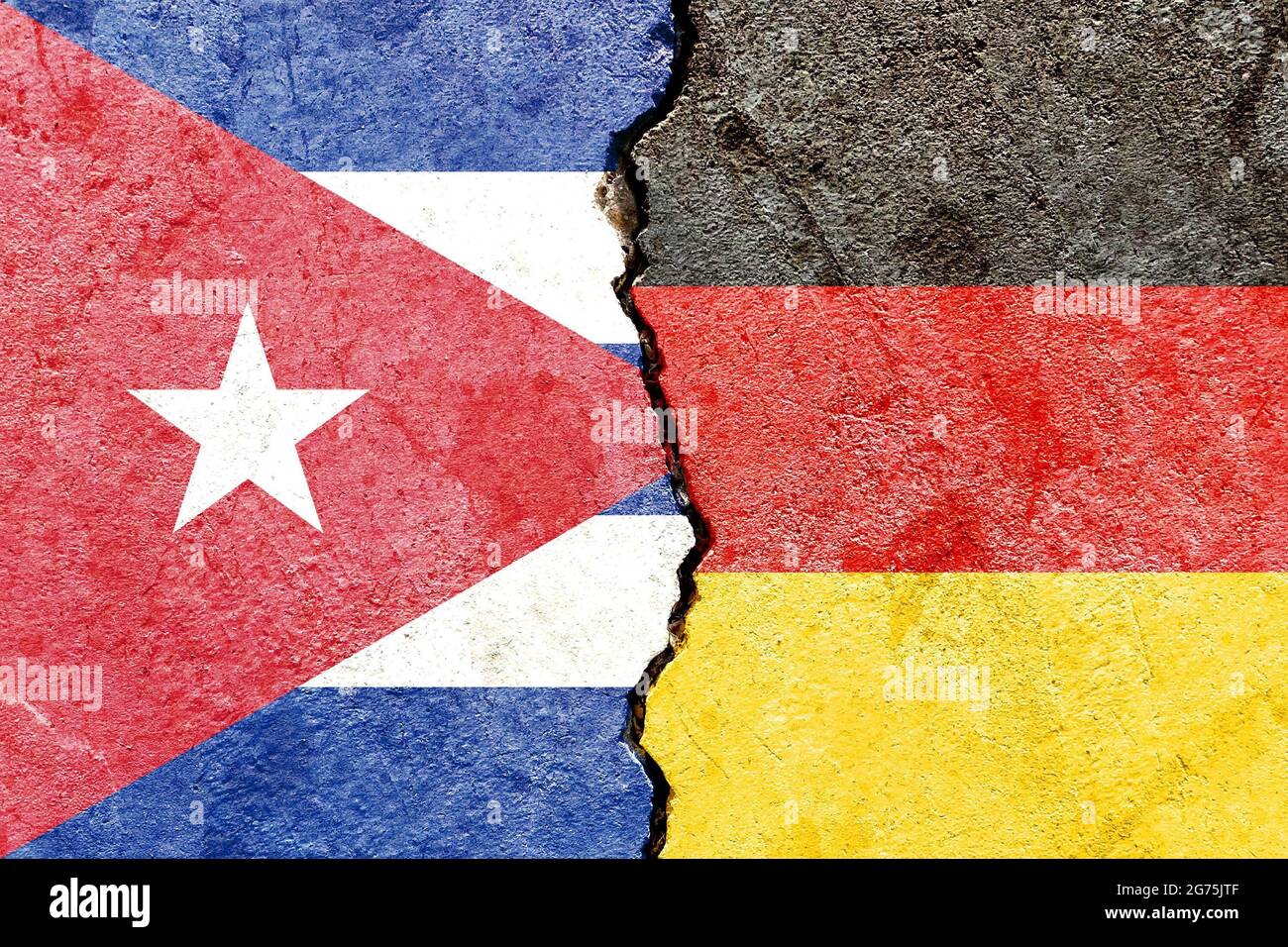 The flags of Cuba and Germany painted on a weathered broken wall ...