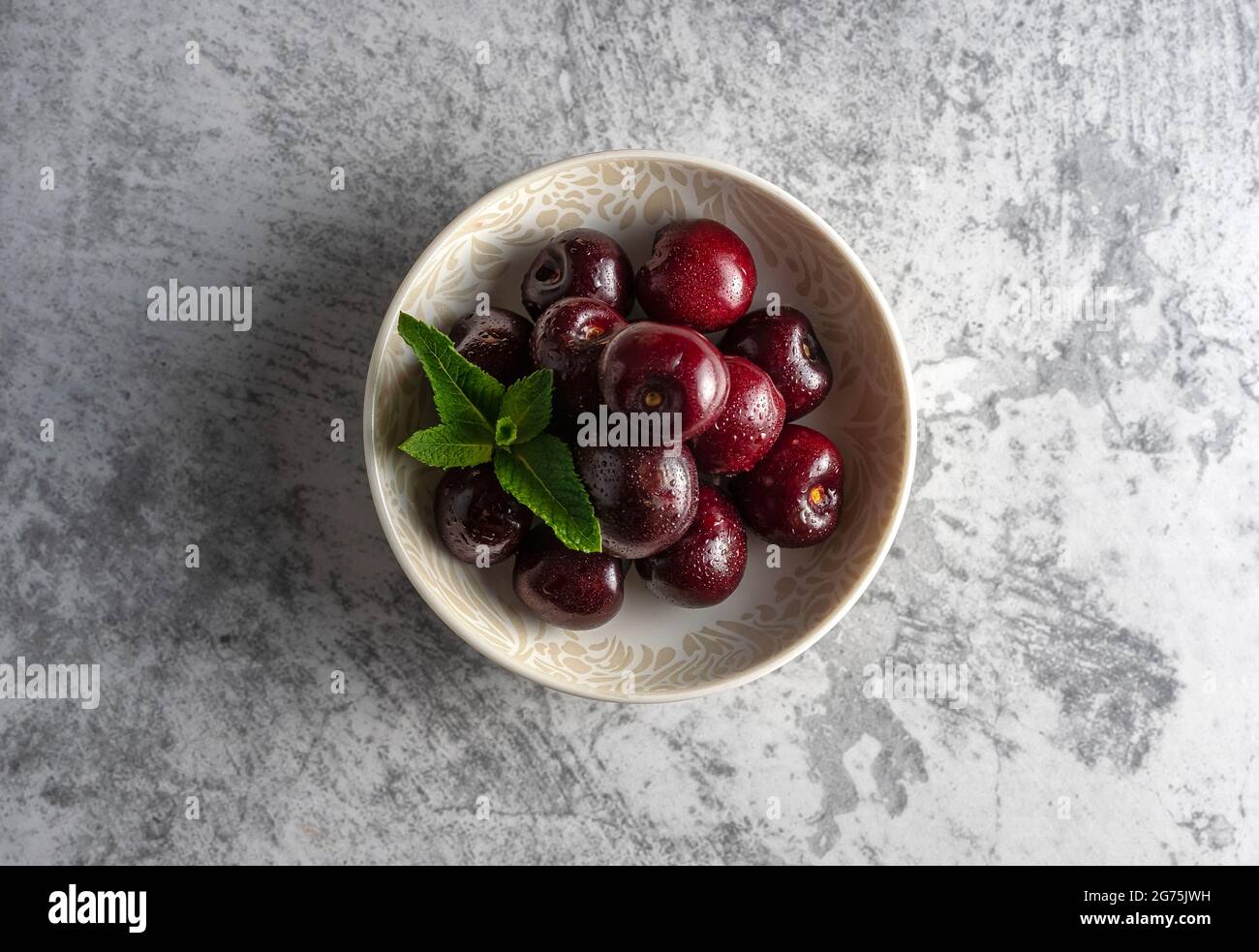 Small bowls filled with cherries placed on a white background ...