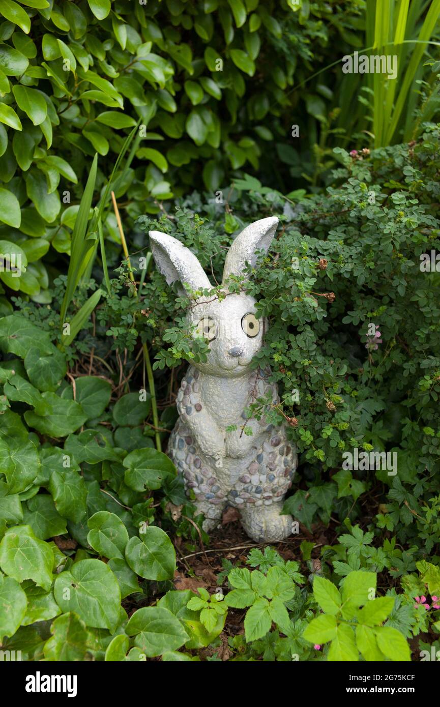 ornamental rabbit with solar powered eyes in a garden border Stock ...