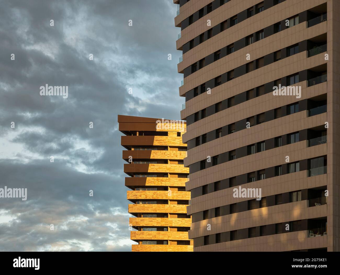 Detail of two facades of a building in an urban area with a cloudy sky ...