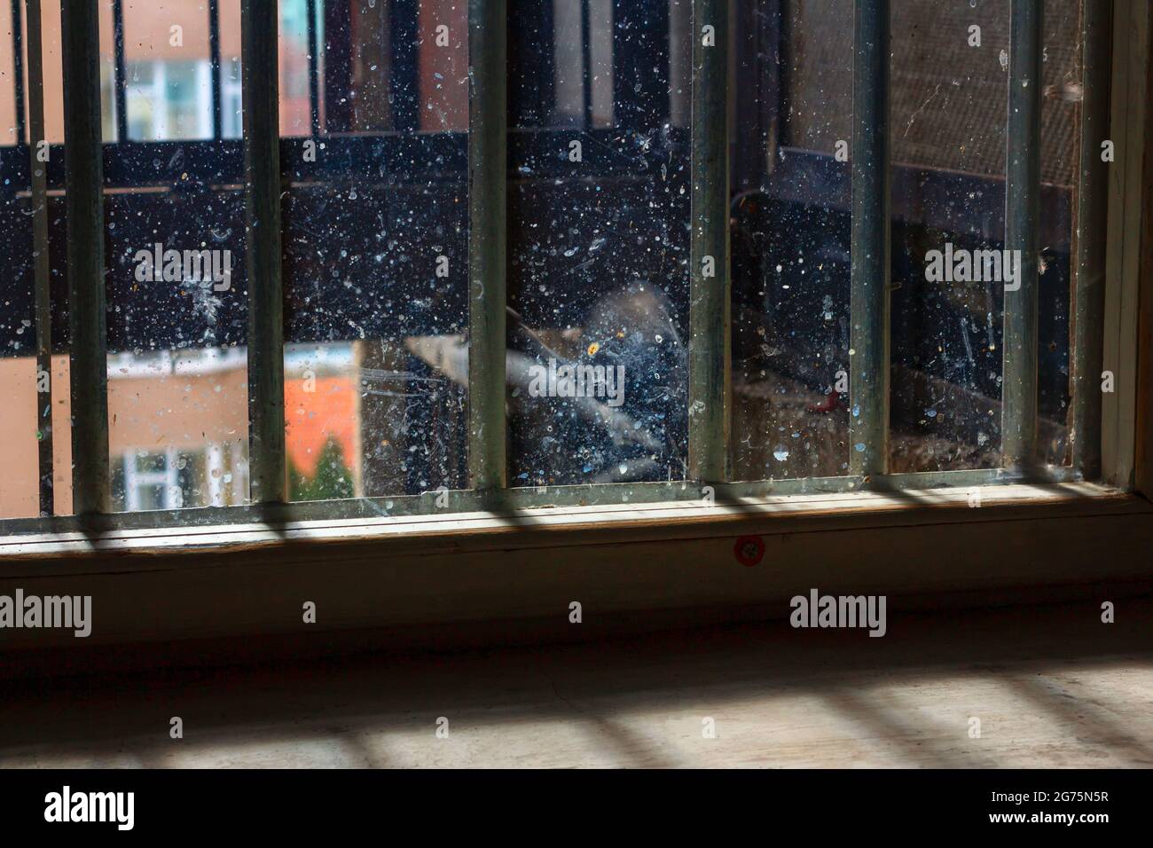 Window with dirty glass and grates . Prison cell with security grates ...
