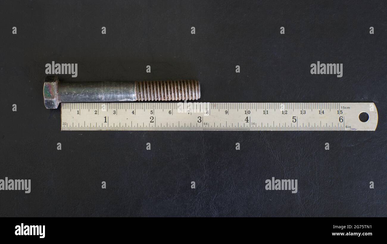 A Bolt and Ruler on a Black Background Stock Photo - Alamy