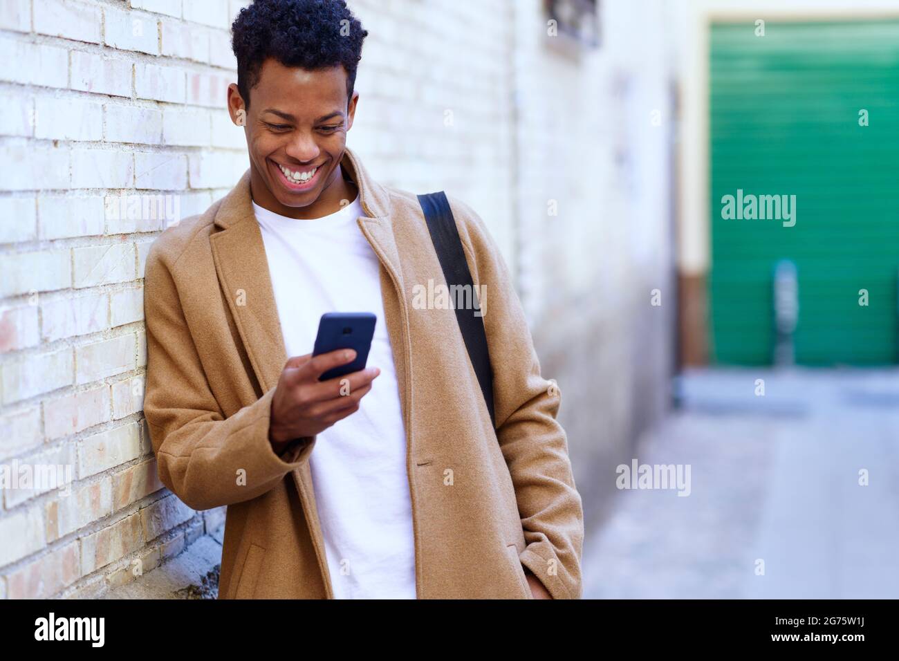 Young black man using his smartphone outdoors Stock Photo - Alamy