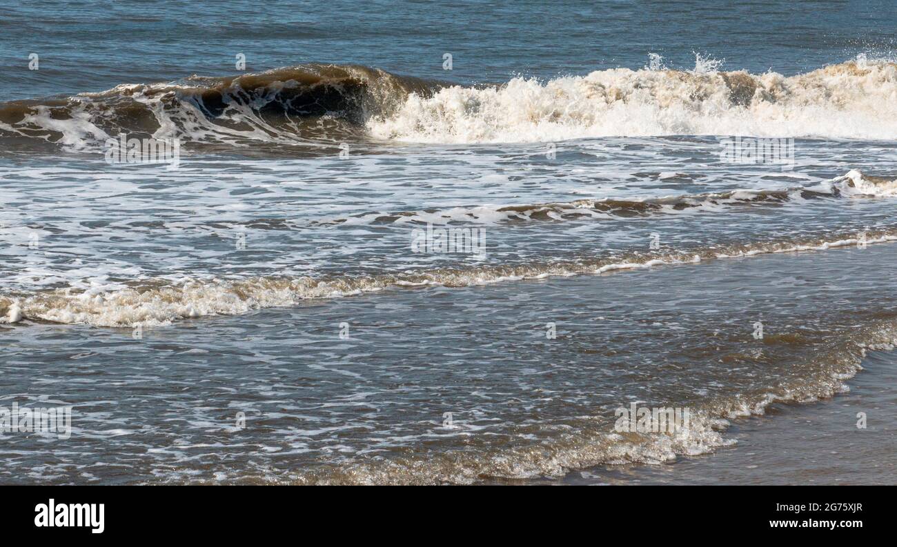 Calm Atlantic Ocean waves rolling on to the shore on the coast of Fire ...