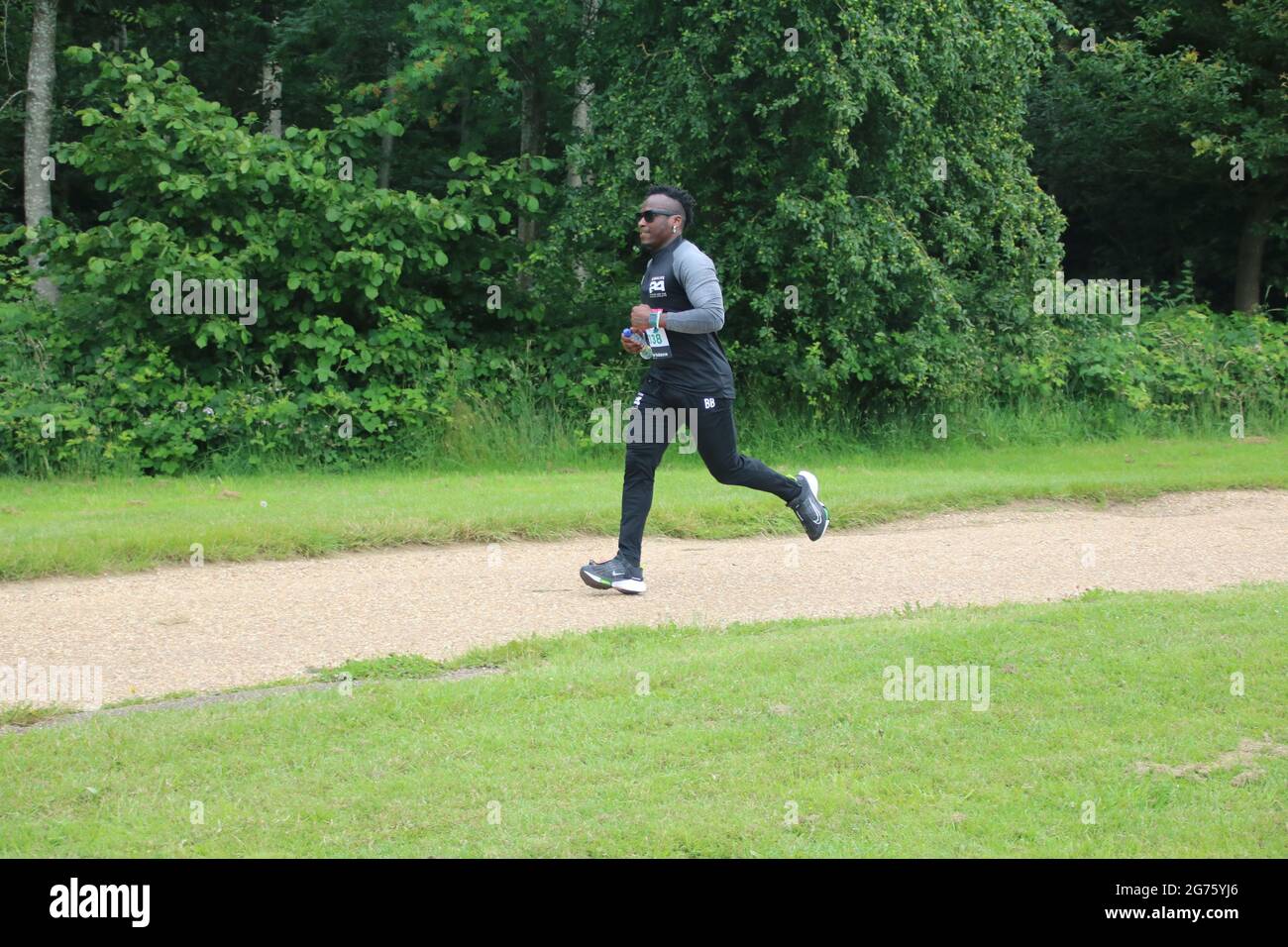 black runner striding out in a race Stock Photo - Alamy