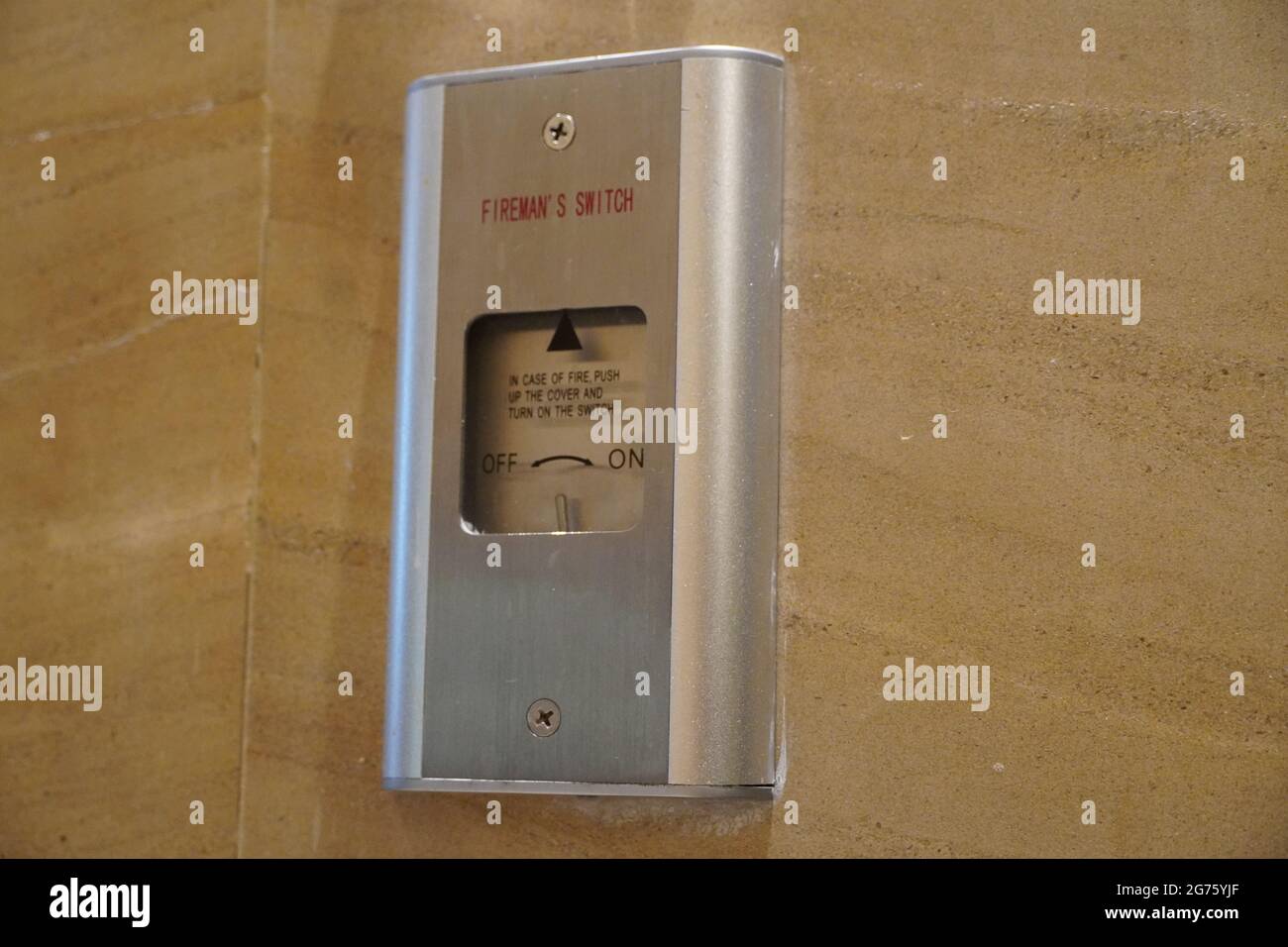 Closeup of a sign stating "Fireman Switch" on a hotel lobby wall and a ...