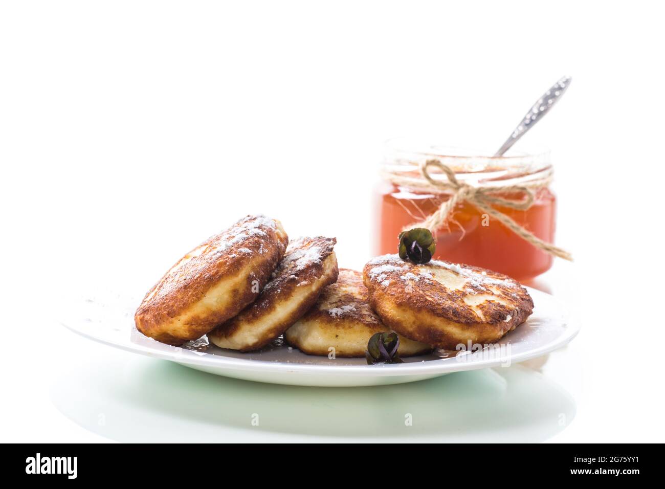 sweet fried cottage cheese pancakes in a plate isolated on white ...
