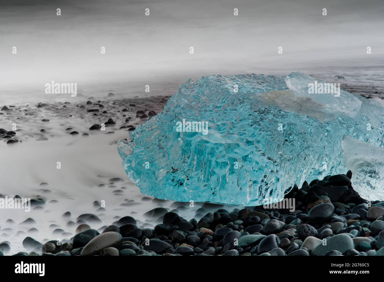 Blue ice block laying on a pebble beach near Jokulsarlon Stock Photo ...