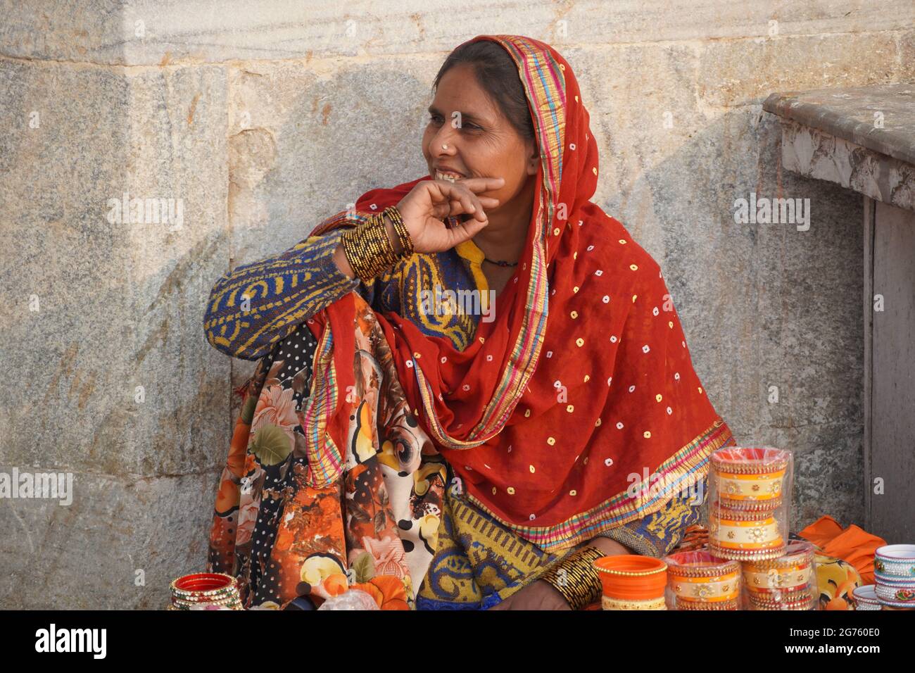An old woman sitting on Indian street market and selling colorful ...