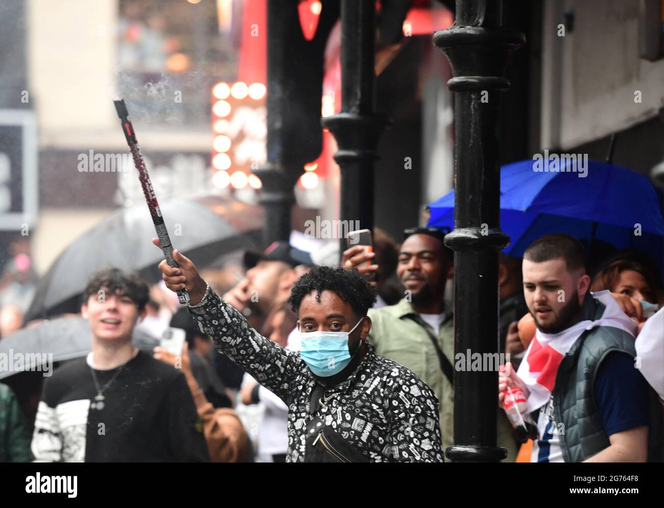 A fan lets off a firework at Leicester Square, London before the UEFA ...