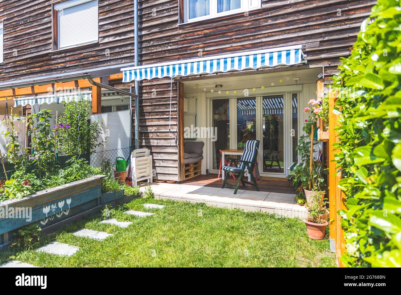 Cozy little green garden with raised bed and veranda, summer time Stock ...