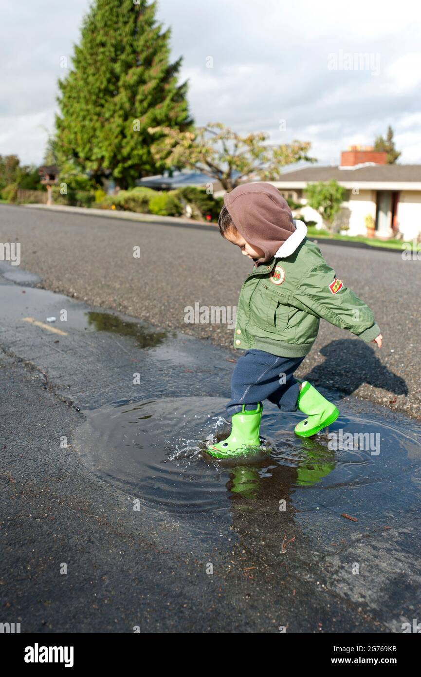 Boy playing in puddle Stock Photo - Alamy
