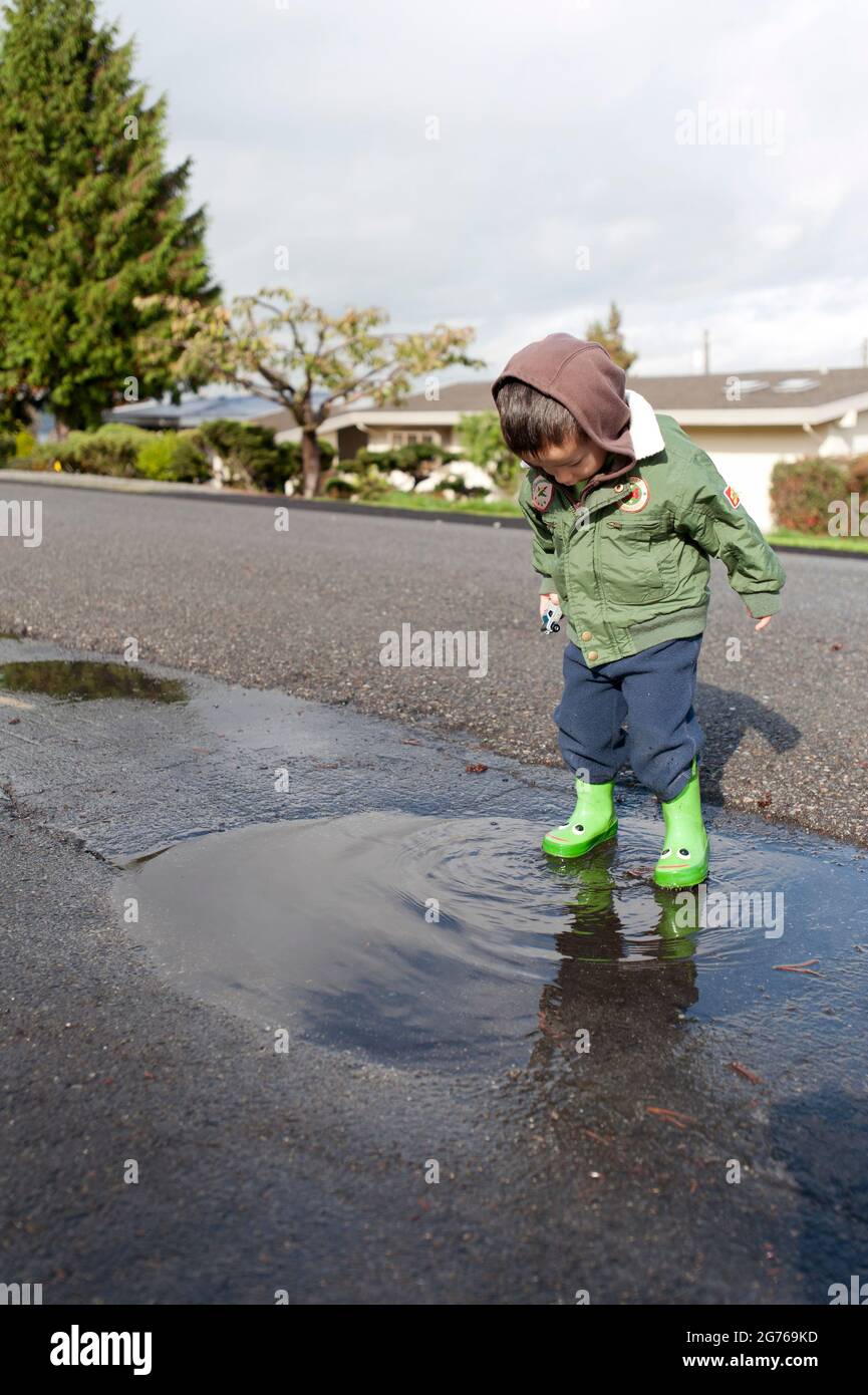 Boy playing in puddle Stock Photo - Alamy