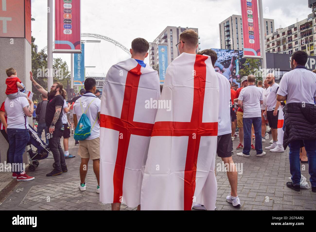 London, UK. 11th July, 2021. Football fans wrapped in English flags ...