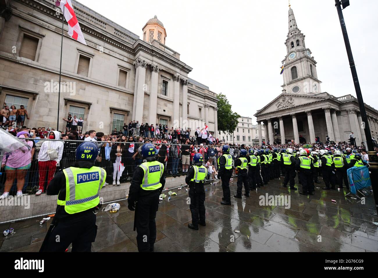 Police officers observe England fans on the steps of the National ...