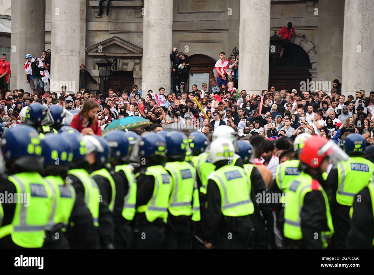 Police officers observe England fans on the steps of the St Martin-In ...