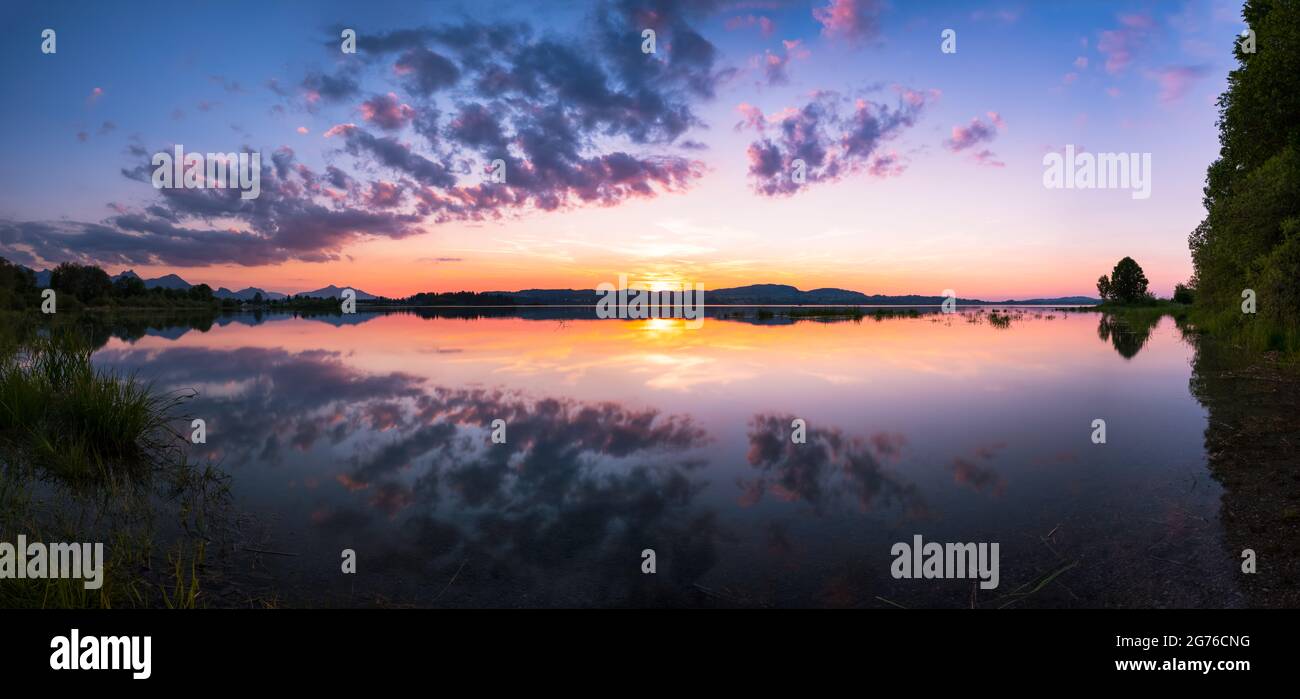 Panoramic view on sunset at lake Forggensee Stock Photo - Alamy
