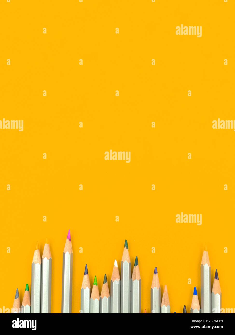 School vertical background with color pencils. Yellow and orange table ...