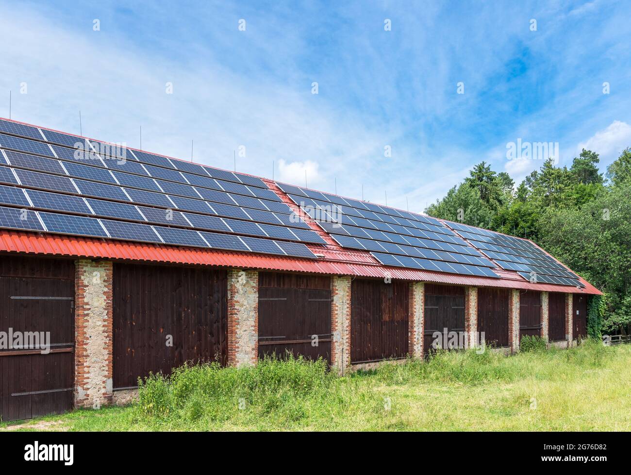 Brick barn in a countryside. Solar panels installed on the roof of the ...