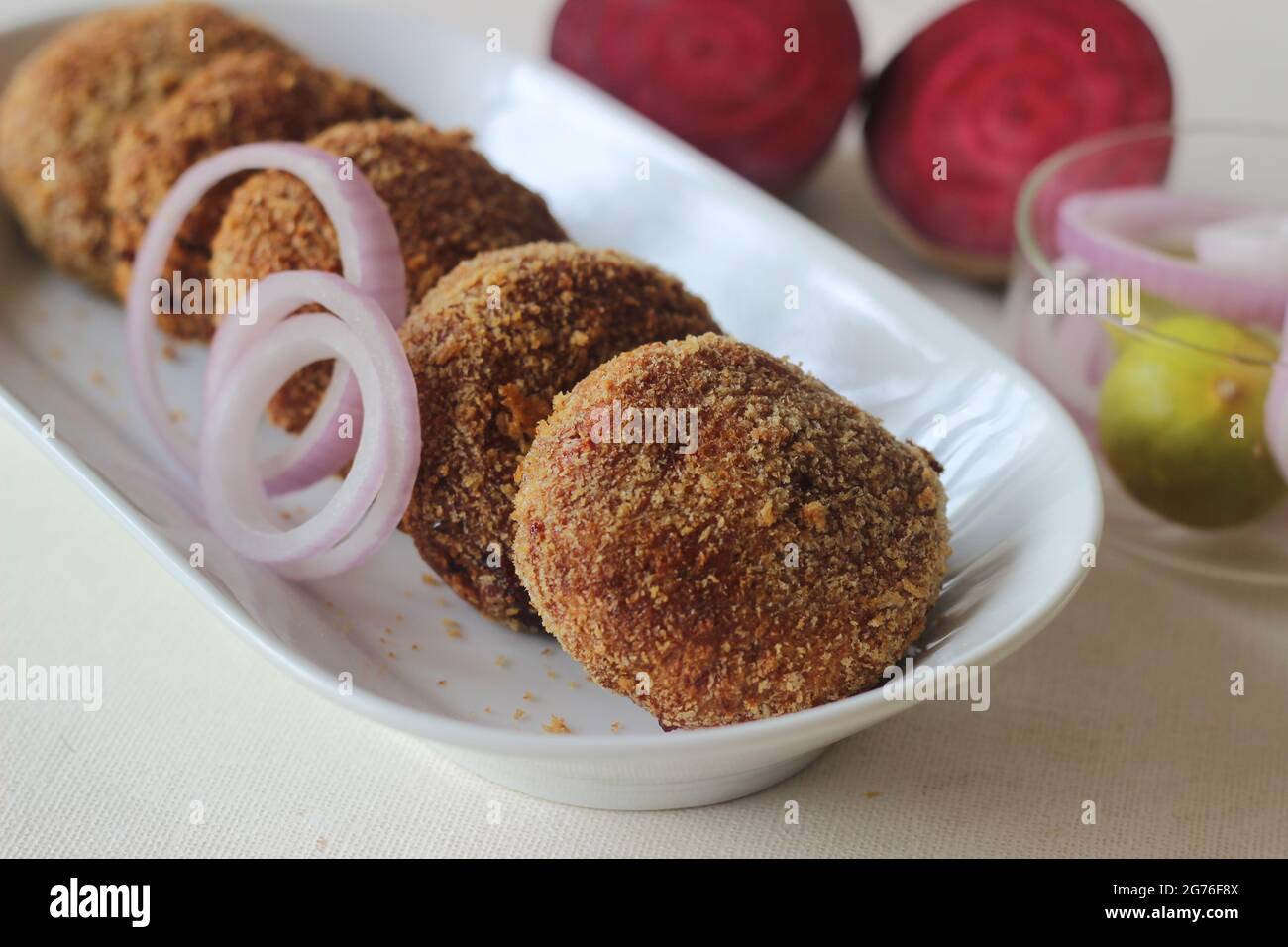 Air fried beetroot cutlets. Served with onions. Shot on white ...